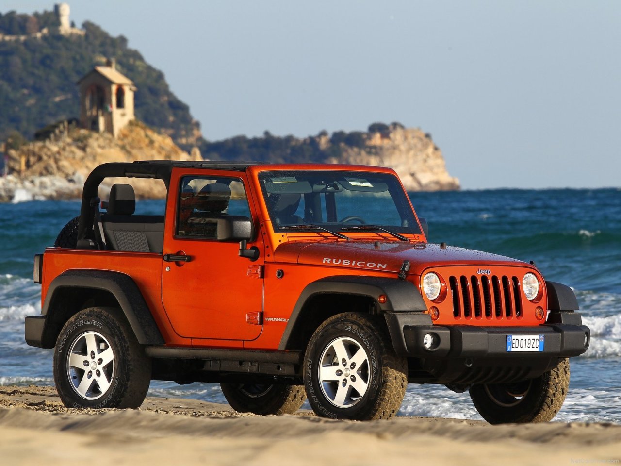 Photo 3 - Jeep Wrangler 2016 rouge sur une plage vue avant droite ...
