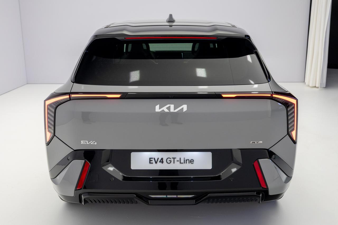 Photo 3 - La signature lumineuse arrière accentue la largeur de la voiture. - Kia EV4 (2025 ...